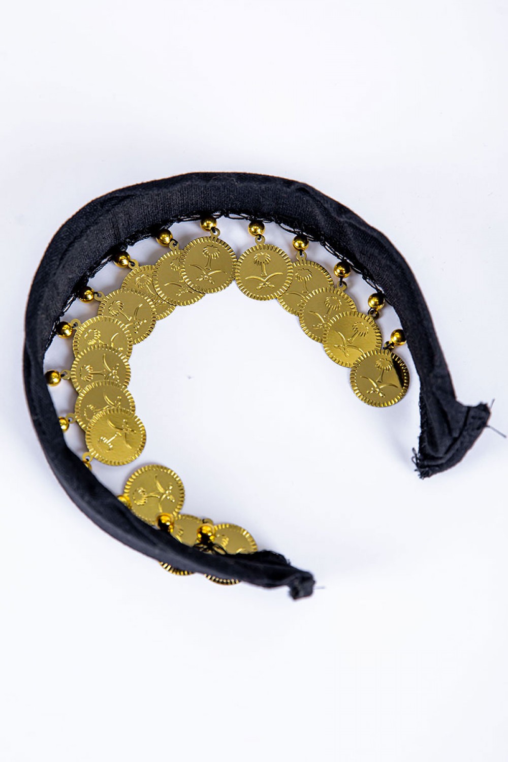 A black traditional hair headband decorated with gold coins