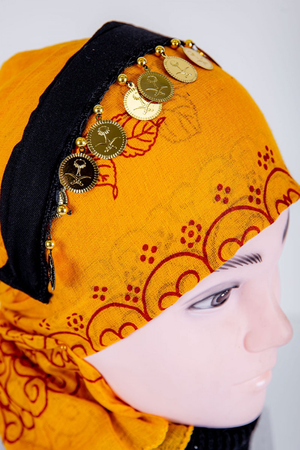 A black traditional hair headband decorated with gold coins