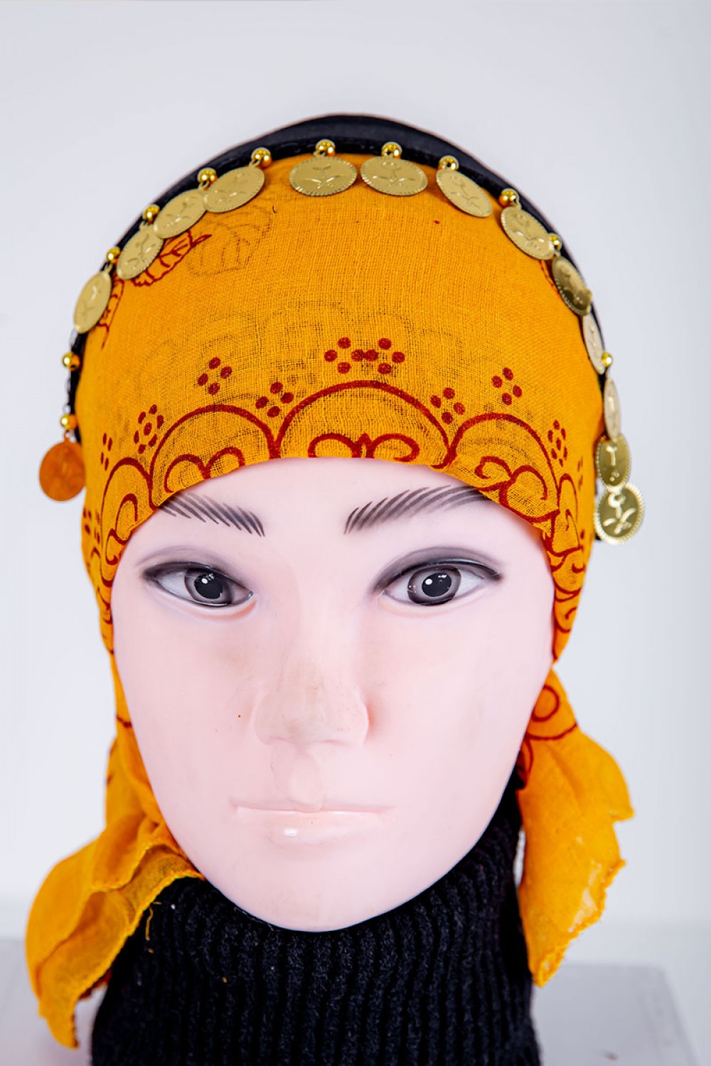 A black traditional hair headband decorated with gold coins